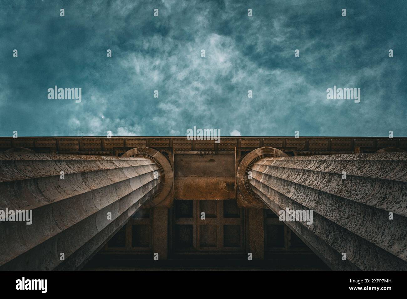 A low angle view of ancient stone columns with a dramatic cloudy sky background Stock Photo - Alamy