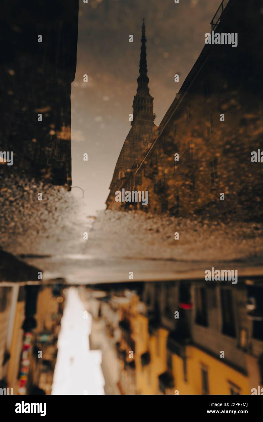 A reflection of a historical building with a spire in a puddle on a ...
