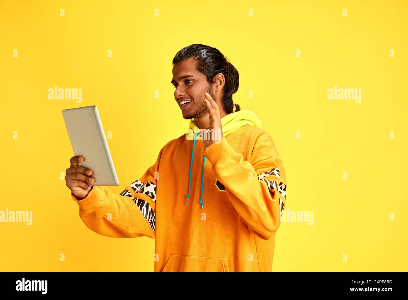 Cheerful young middle eastern man waving hello calling his friends in ...