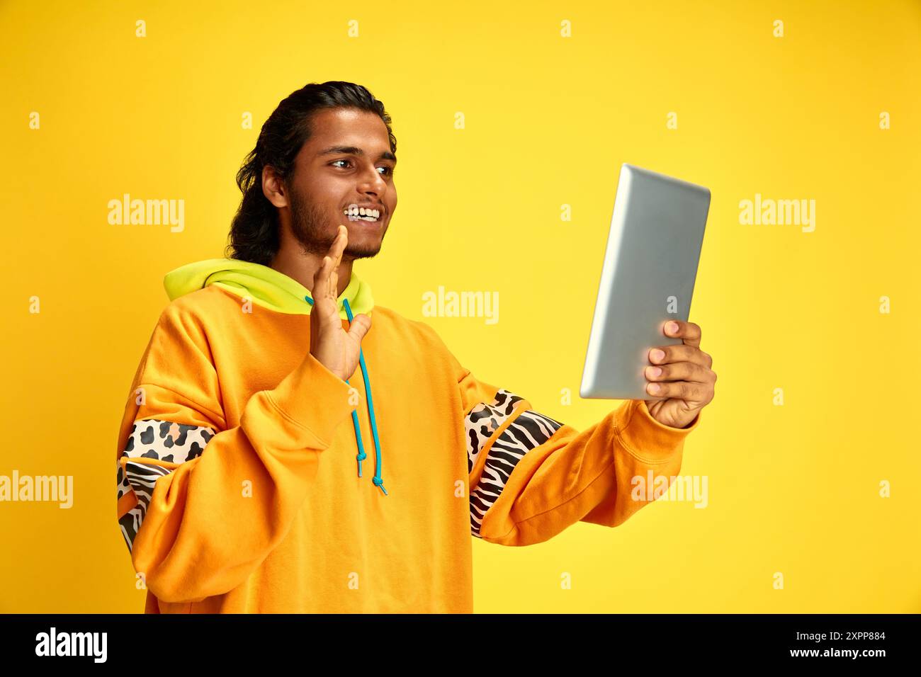 Smiling young middle eastern man waving hello calling his friends in ...