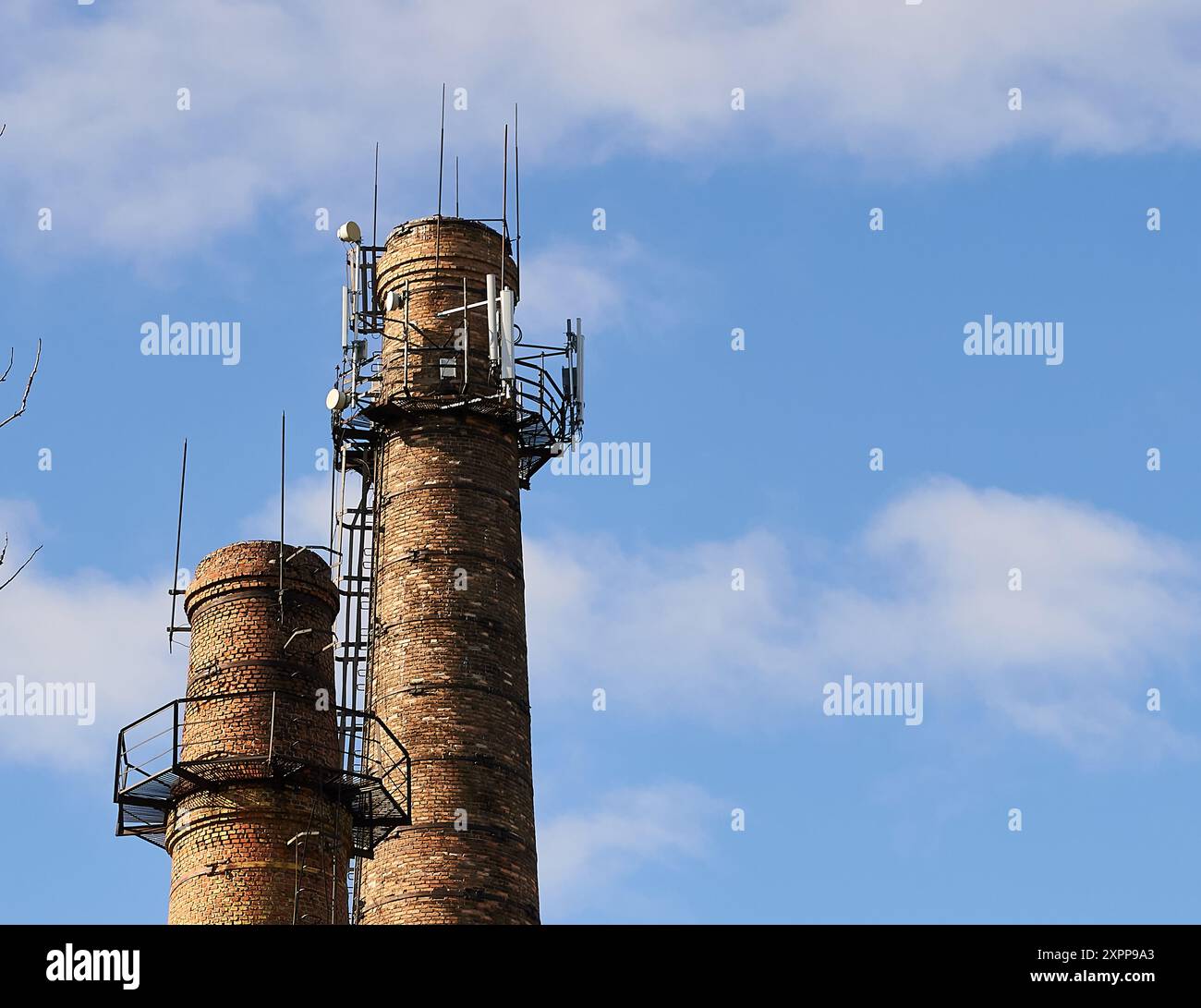 Two cell tower above cellular base station. Brick chimneys of boiler ...