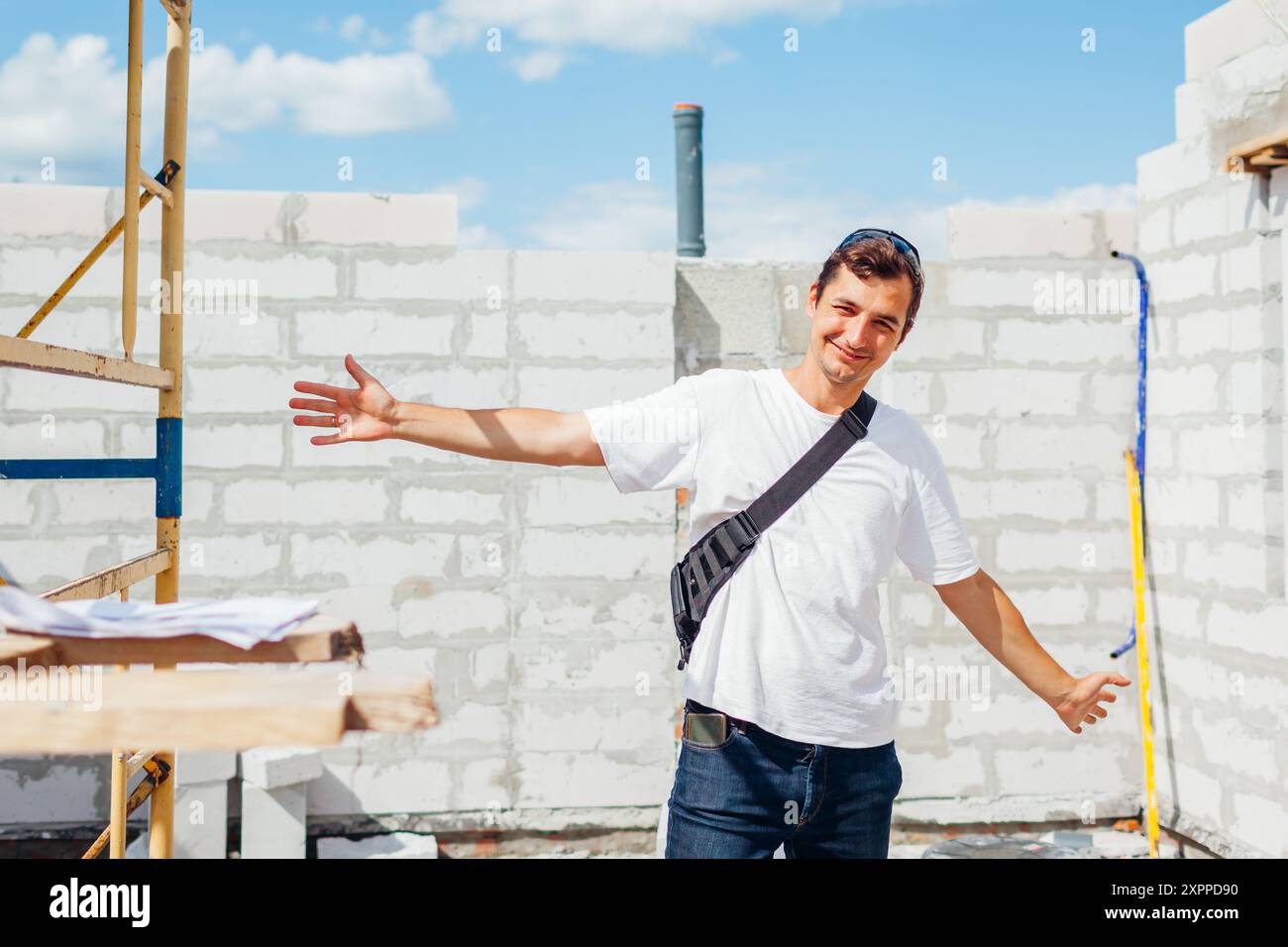 Happy young man checking her house under construction standing inside ...