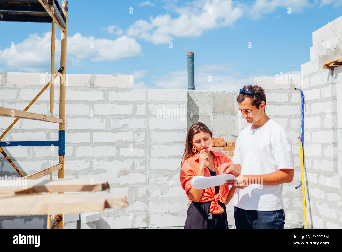 Man architect engineer showing house under construction to woman future ...