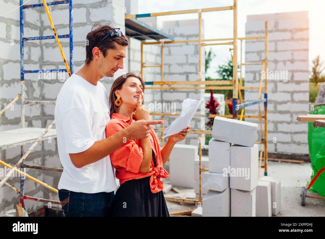 Happy young couple checking their future house under construction ...
