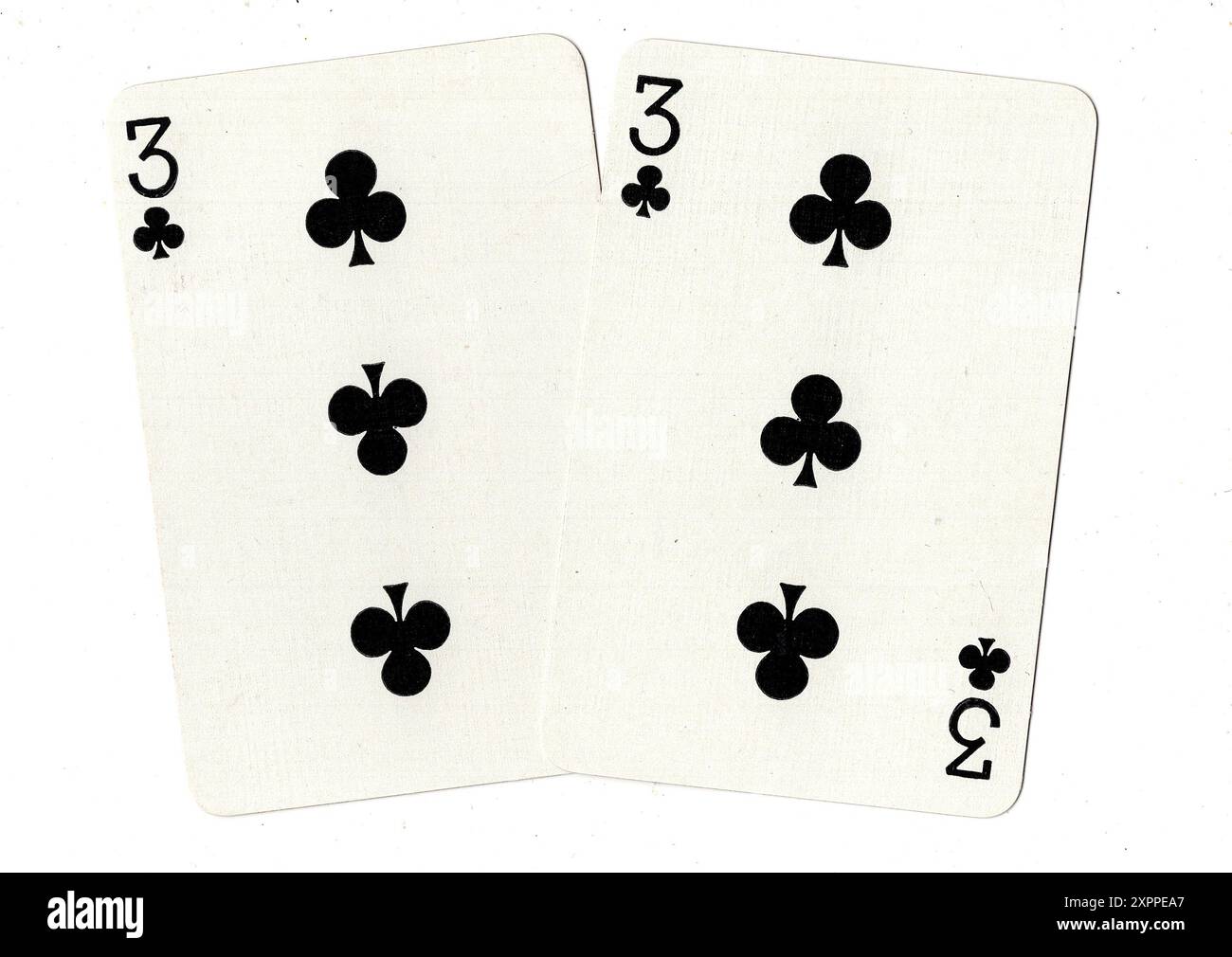 A pair of vintage three of clubs playing cards on a white background ...