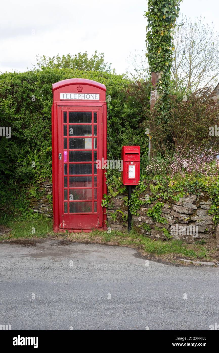 An old red British public telephone box and pole mounted letter box on ...