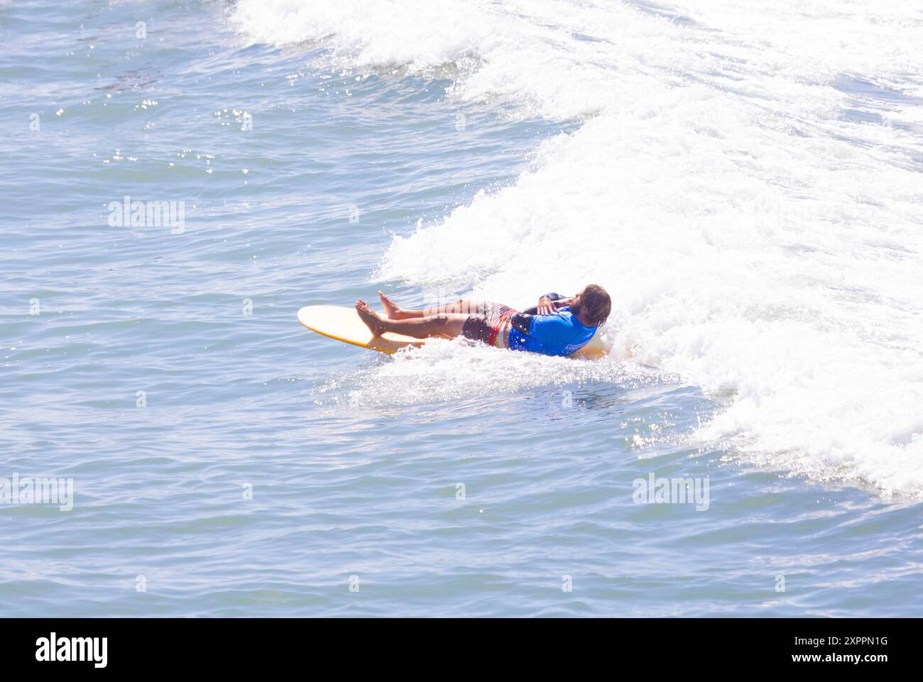 Longboard Surfer Lying Down Riding Wave Stock Photo - Alamy