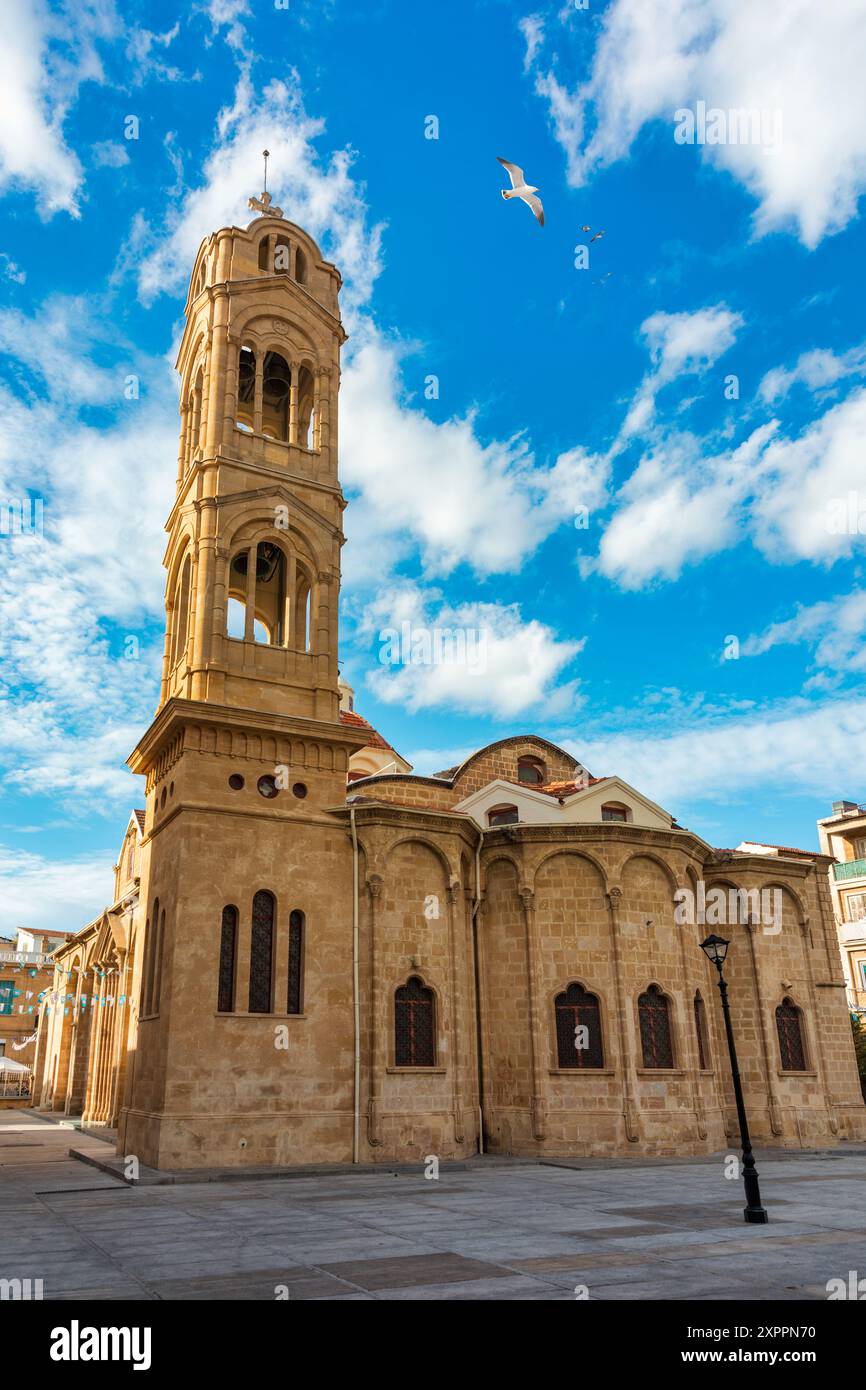 A small building with a blue door sits in front of a large Mosque with ...
