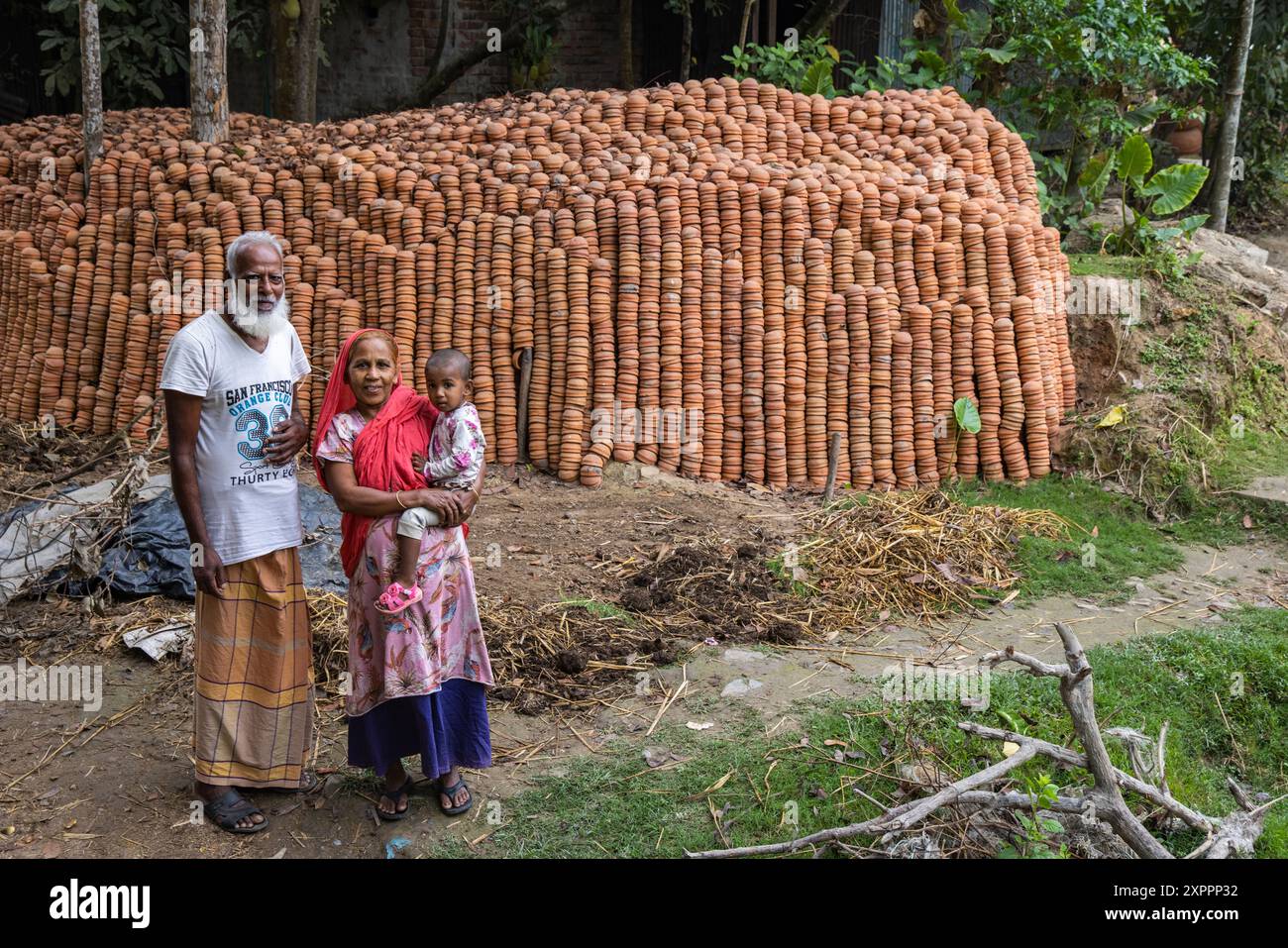 Family portrait in front of huge quantities of ceramic pots in Kumar ...