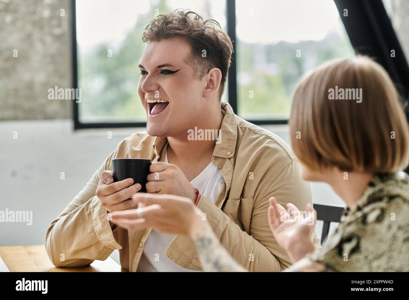 Friends share laughter and coffee in a cozy home atmosphere Stock Photo ...