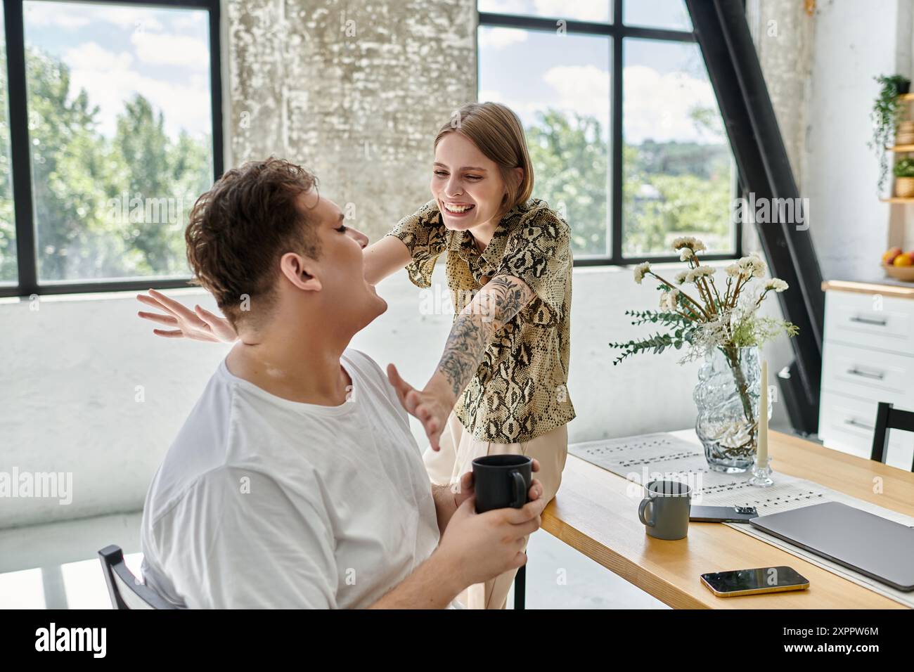 Two friends share a moment of laughter in a modern, cozy living space ...