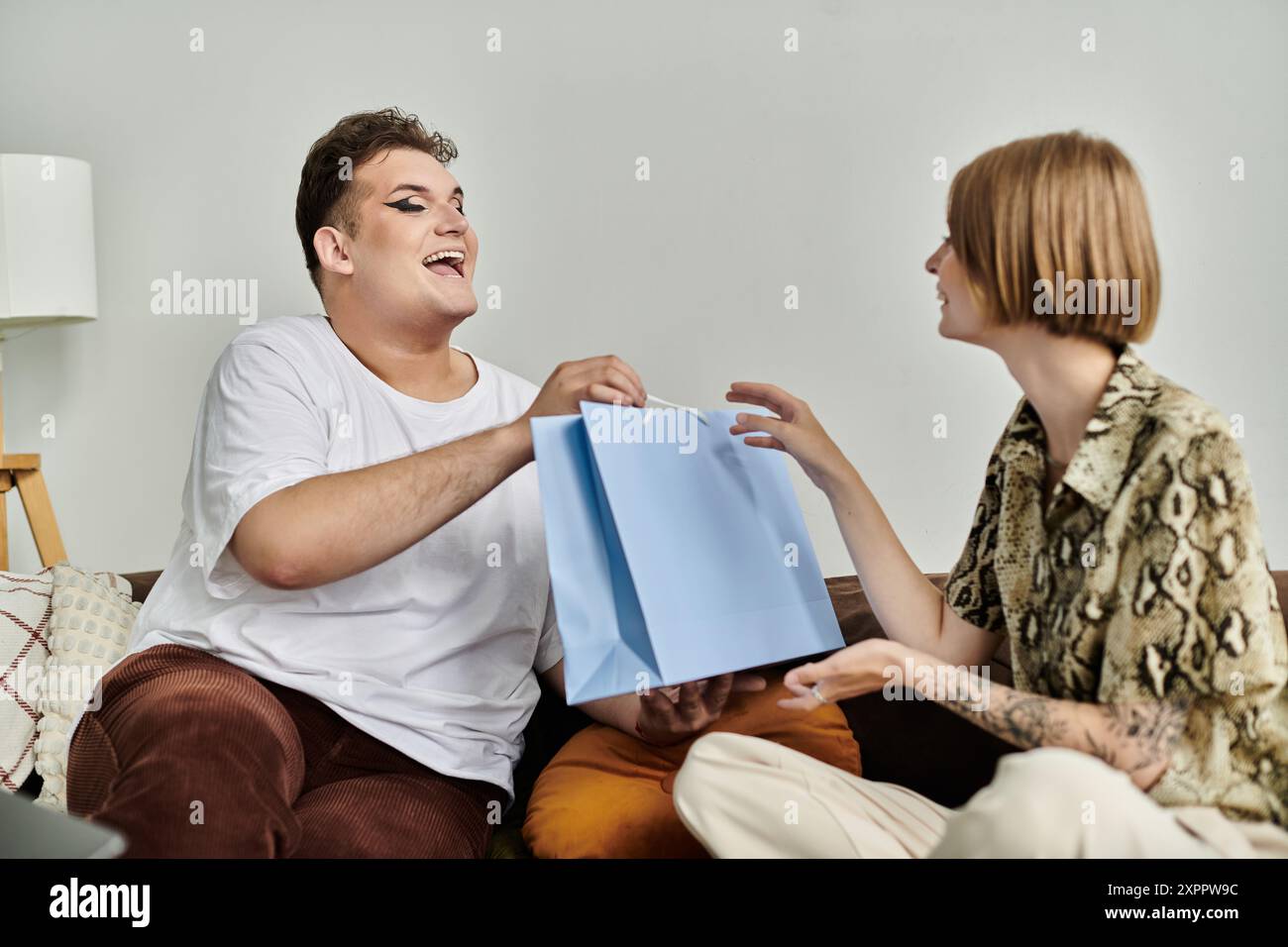 A joyful moment shared between two friends while unwrapping a gift ...
