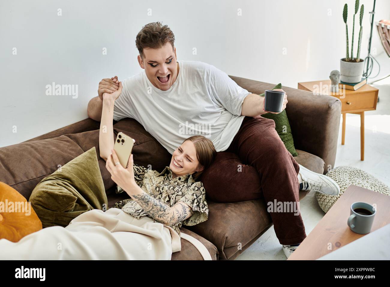 Two friends share laughter and joy while relaxing together on the couch ...