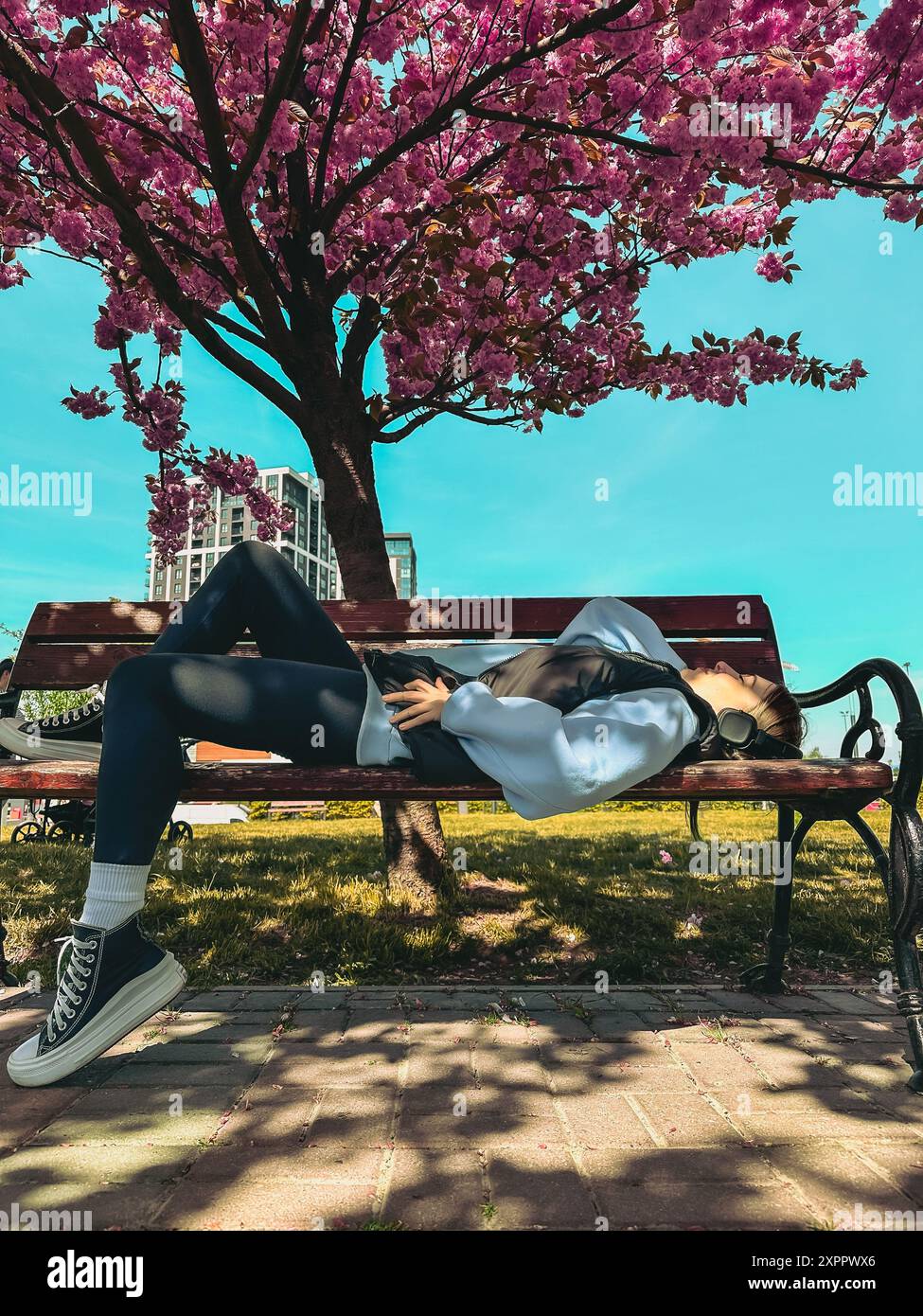 woman laying down on the bench listening music Stock Photo - Alamy