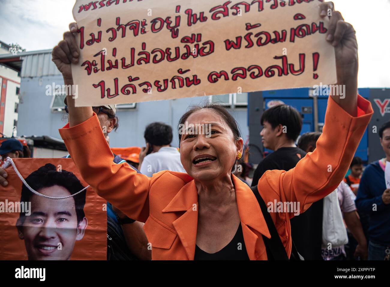 A supporter of the Move Forward Party holds a placard expressing her opinion while shouting ...