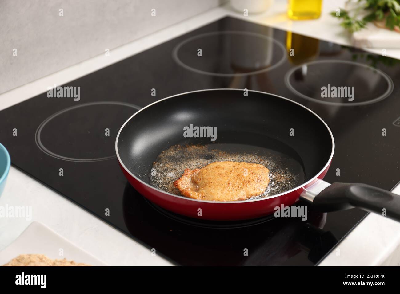 Cooking schnitzel in frying pan on stove, closeup Stock Photo - Alamy