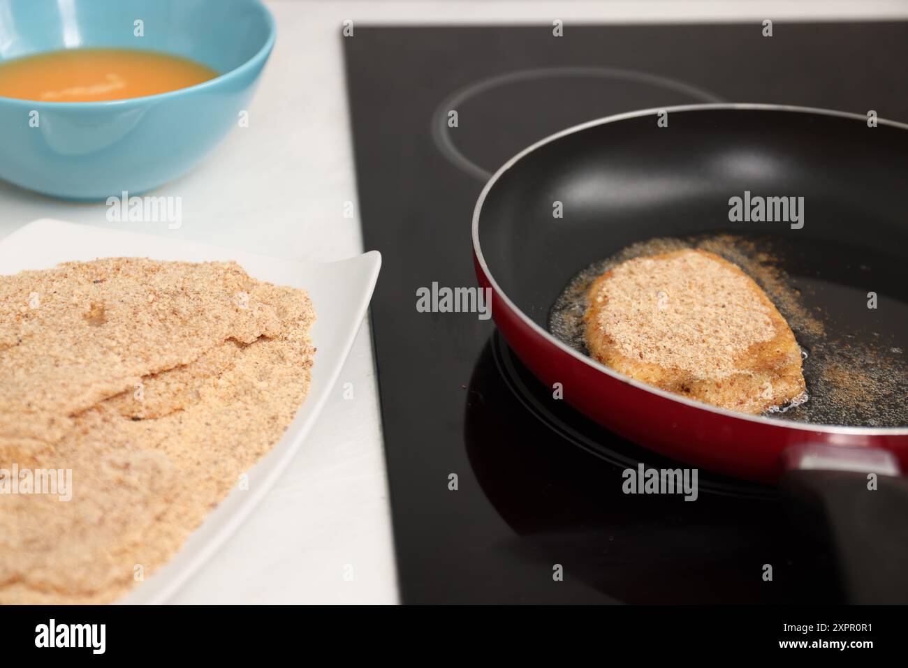 Cooking schnitzel in frying pan on stove, closeup Stock Photo - Alamy