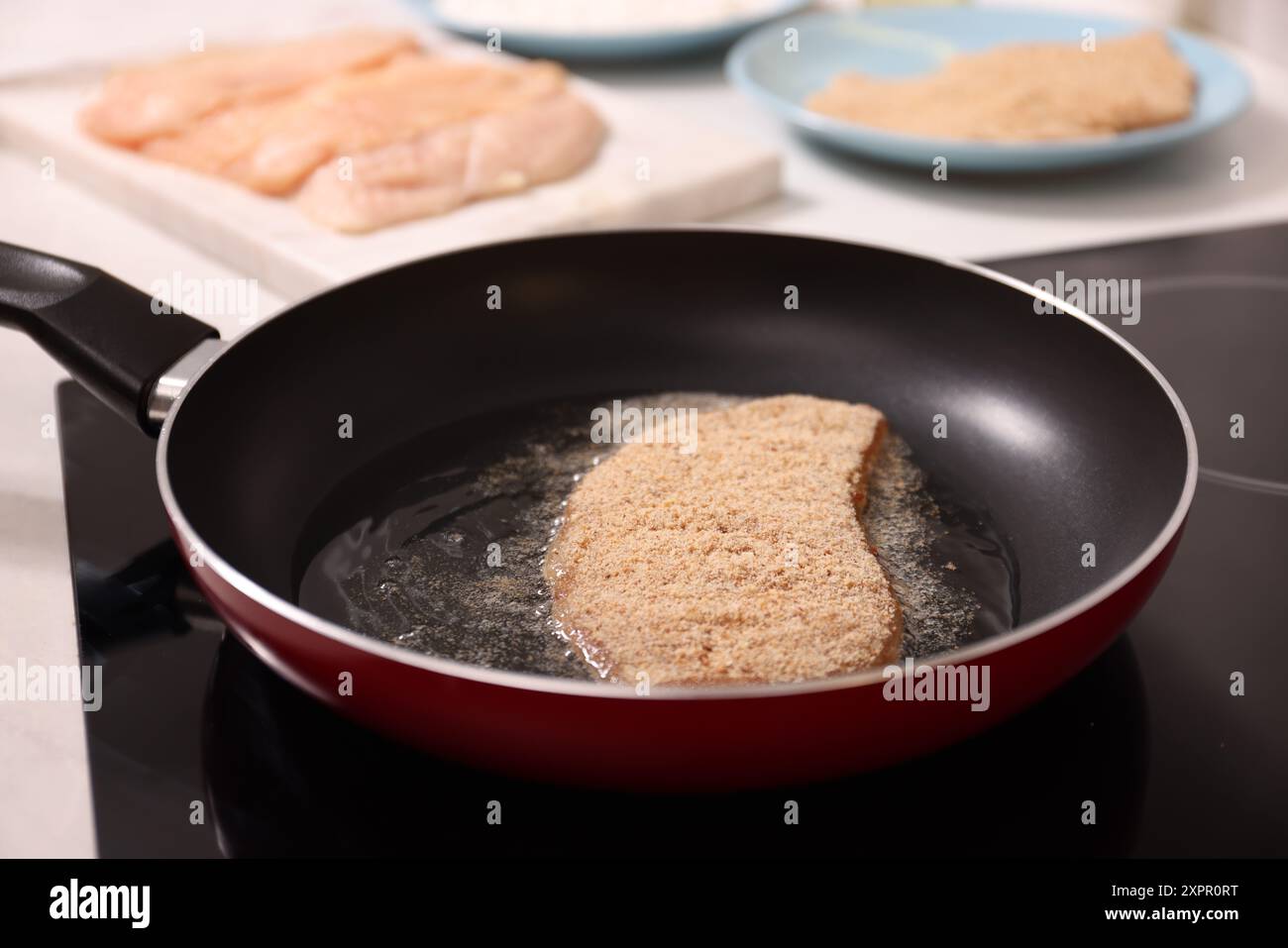 Cooking schnitzel in frying pan on stove, closeup Stock Photo - Alamy