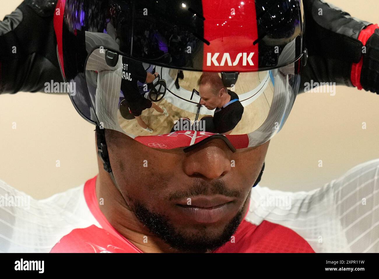 The image of a team staffer is reflected in the helmet of Nicholas Paul ...