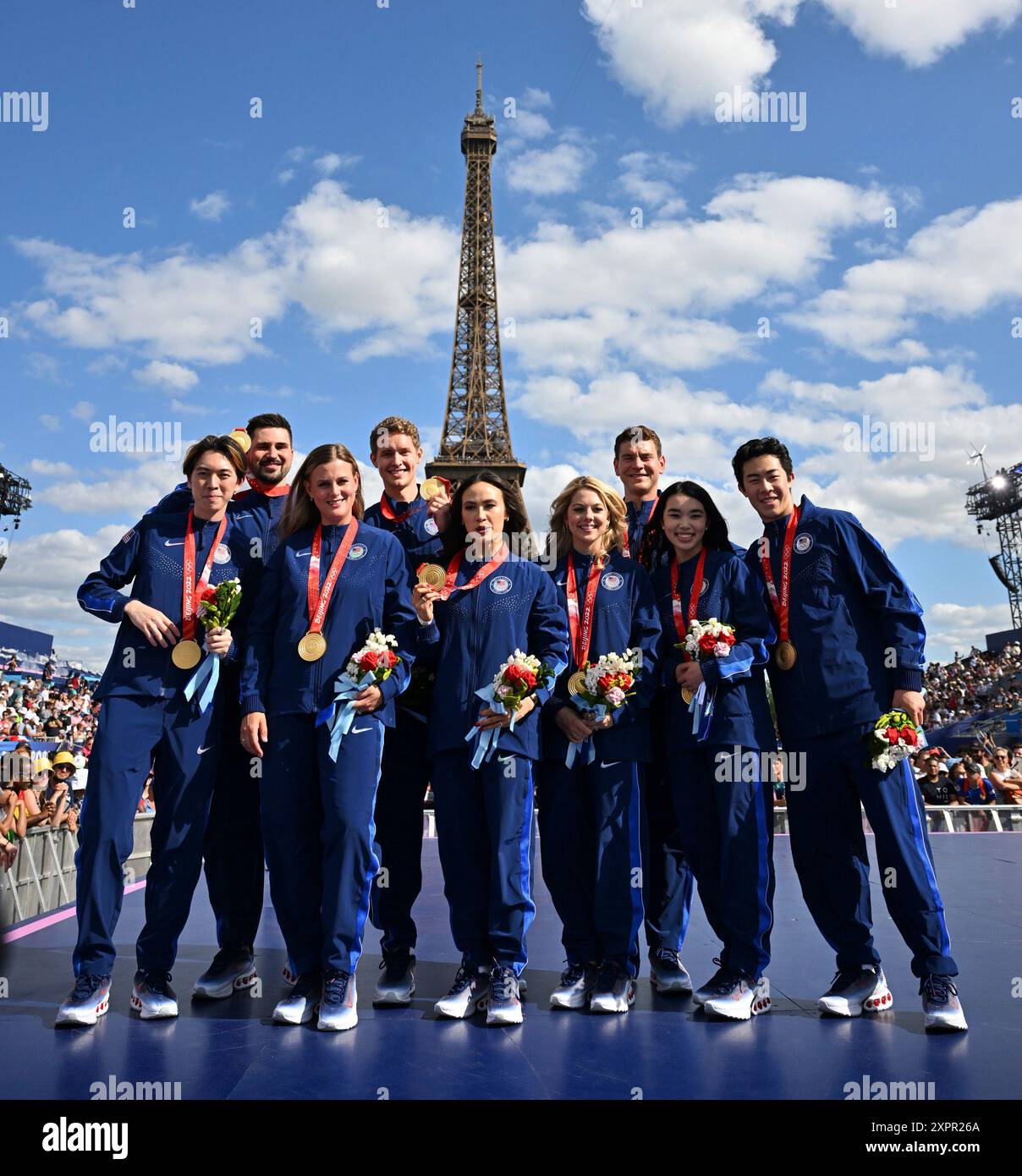 Figure skaters of Team America pose for cameras against a backdrop of ...