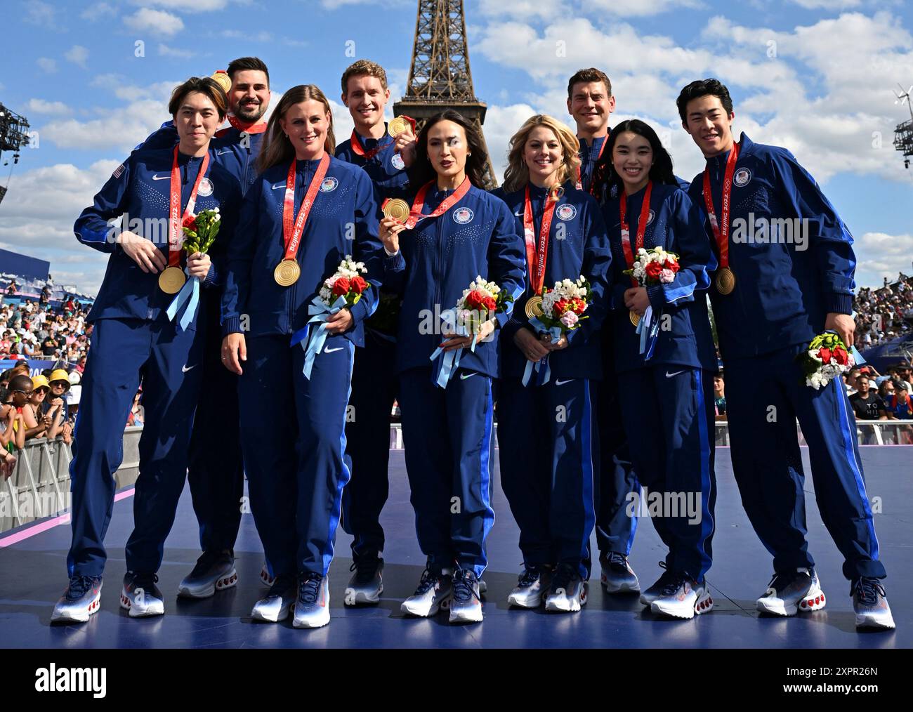 Figure skaters of Team America pose for cameras against a backdrop of ...