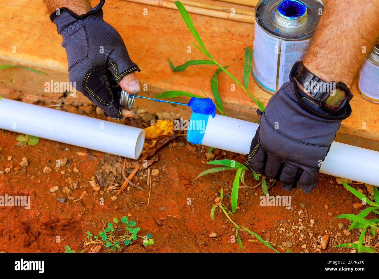 Plumbing contractor installing glue PVC pipes to lay water line Stock ...