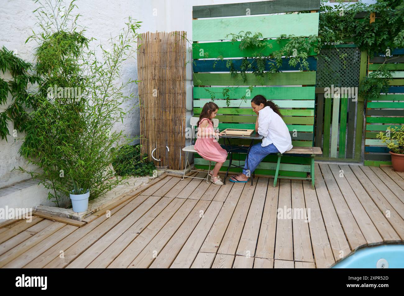 Mother and daughter sharing quality time together on a cozy patio with ...