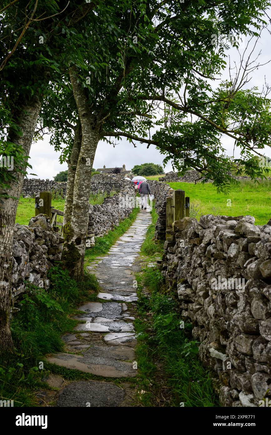 Grassington Yorkshire UK-27 July 2024. A rustic stone path winding through lush greenery and ...