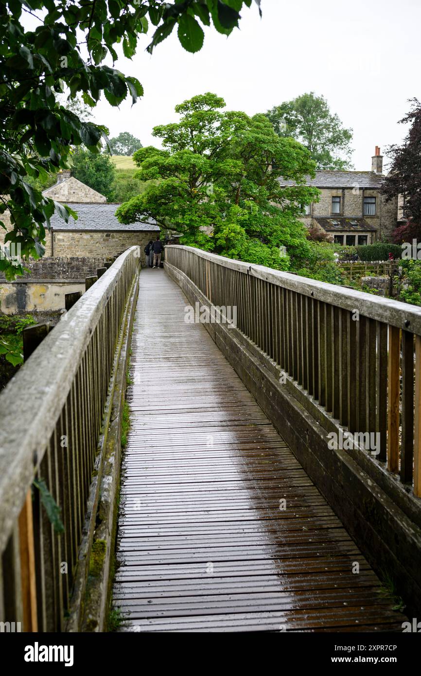 Grassington Yorkshire UK-27 July 2024. A serene wooden bridge leading ...