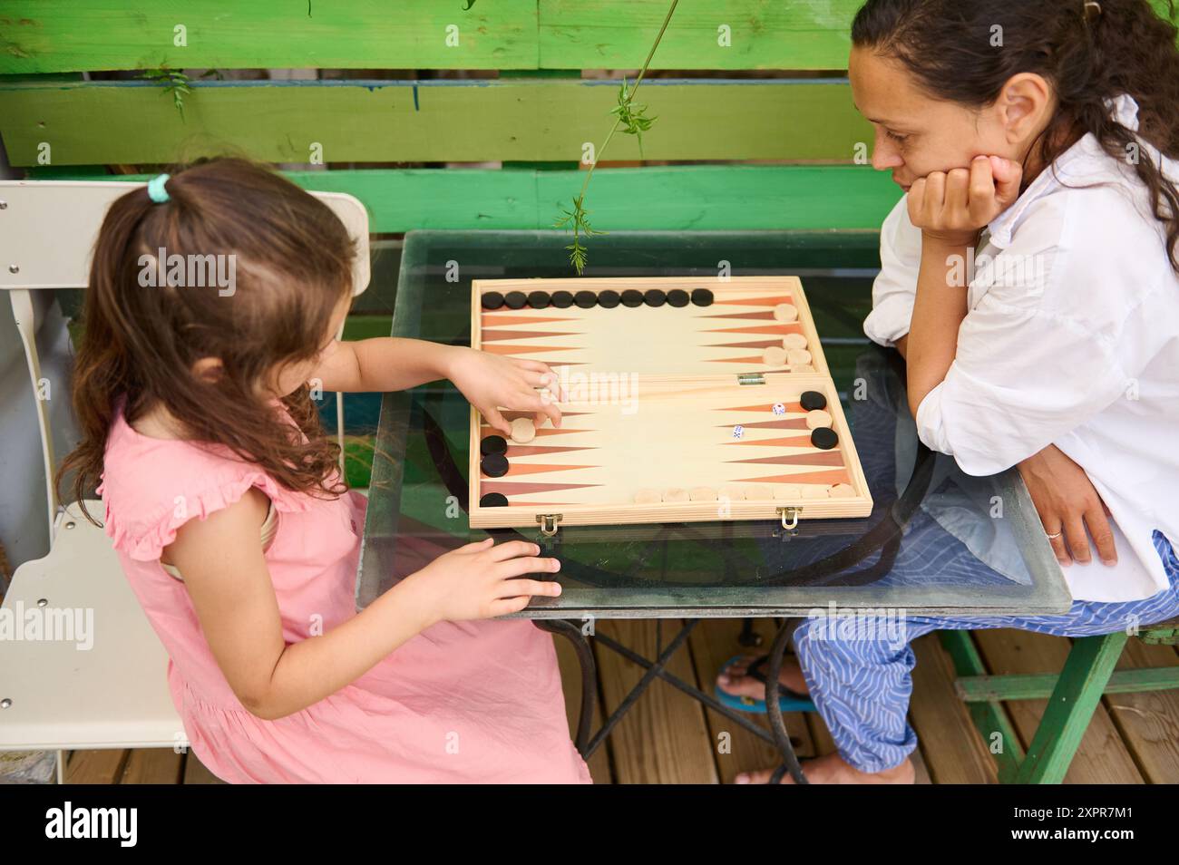 Mother and daughter engaging in a game of backgammon, enjoying quality ...