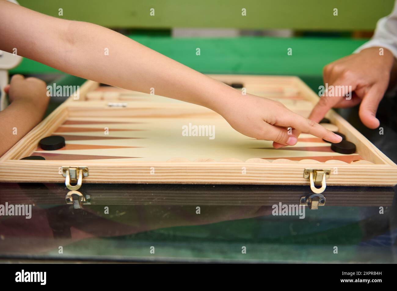 Close-up of a backgammon game in progress, showing two hands, one ...