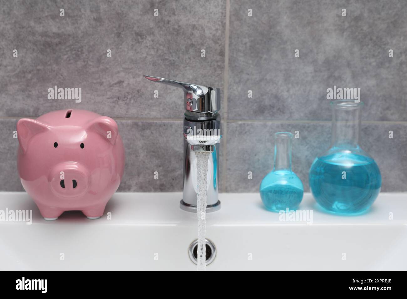 Water saving concept. Piggy bank, glassware with liquid and stream of ...
