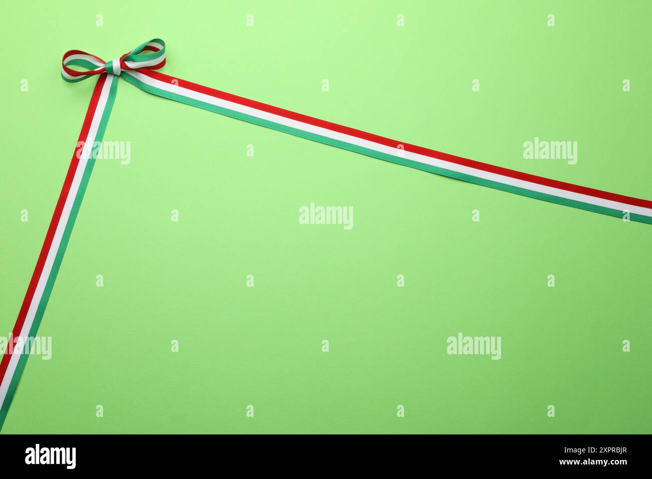 Ribbon with bow in colors of Hungarian flag on green background, top ...