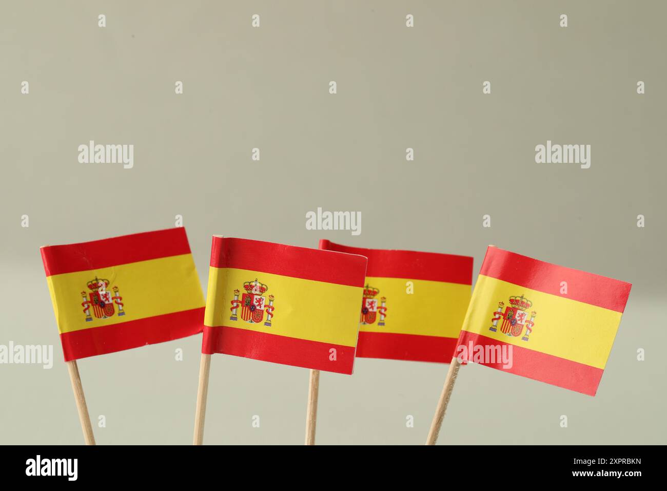 Small paper flags of Spain on light background Stock Photo - Alamy