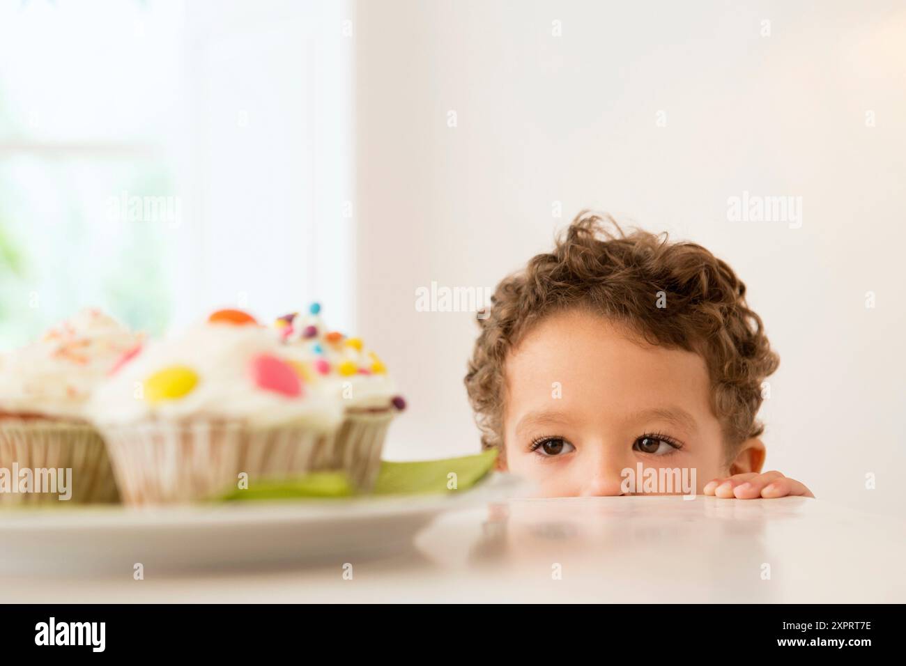 Four year old boy waiting for a cupcake Stock Photo - Alamy