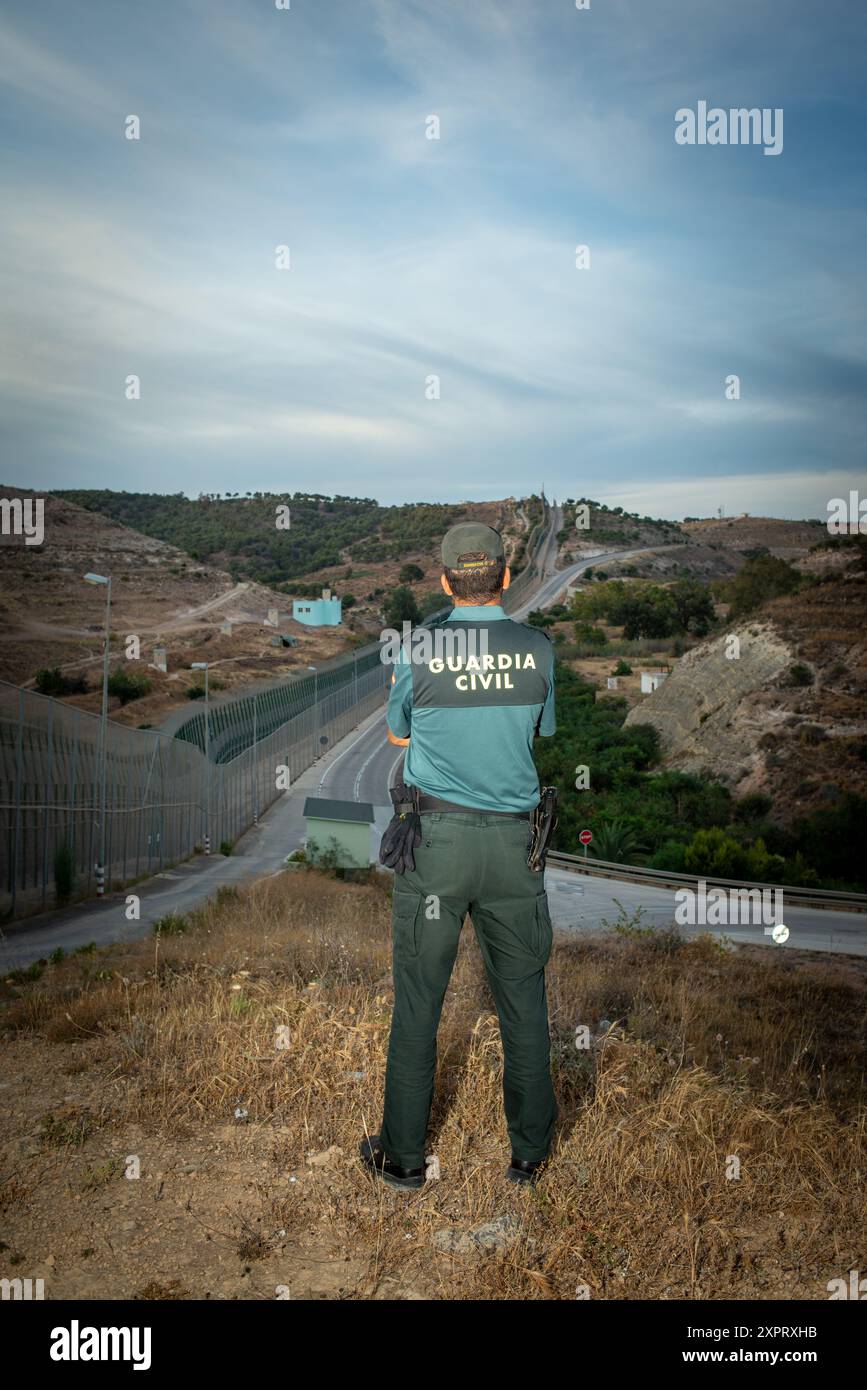 Guardia Civil officer observing the perimeter fence of the European ...