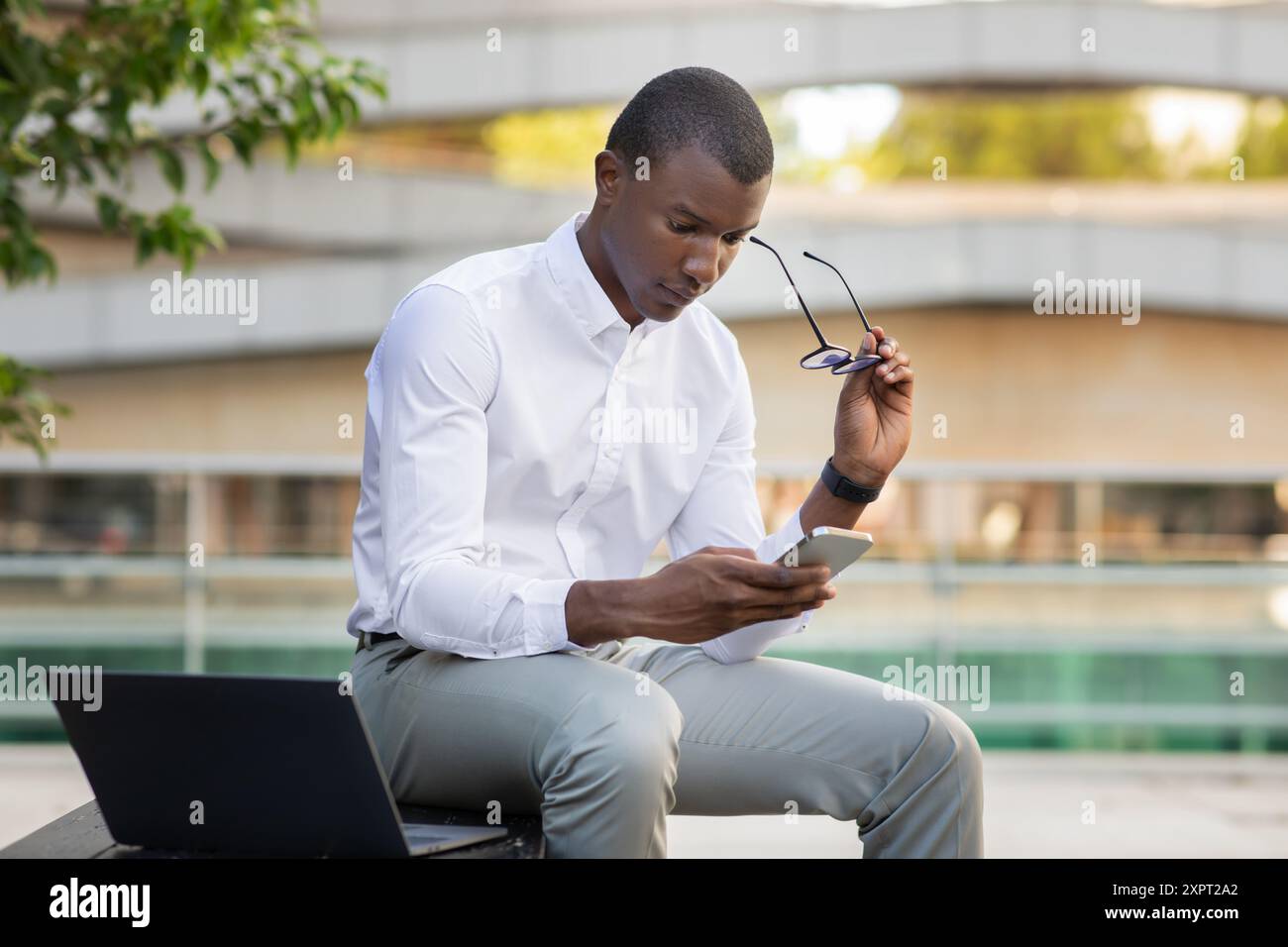 Young Man Engaged in Thoughtful Reflection While Using Smartphone Stock ...