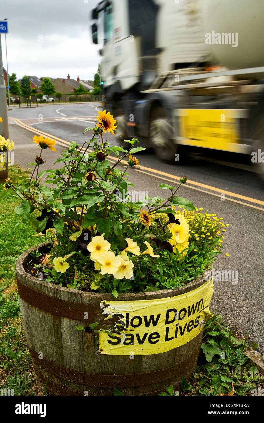 Concrete mixer passing floral planter displaying to oncoming traffic a ...