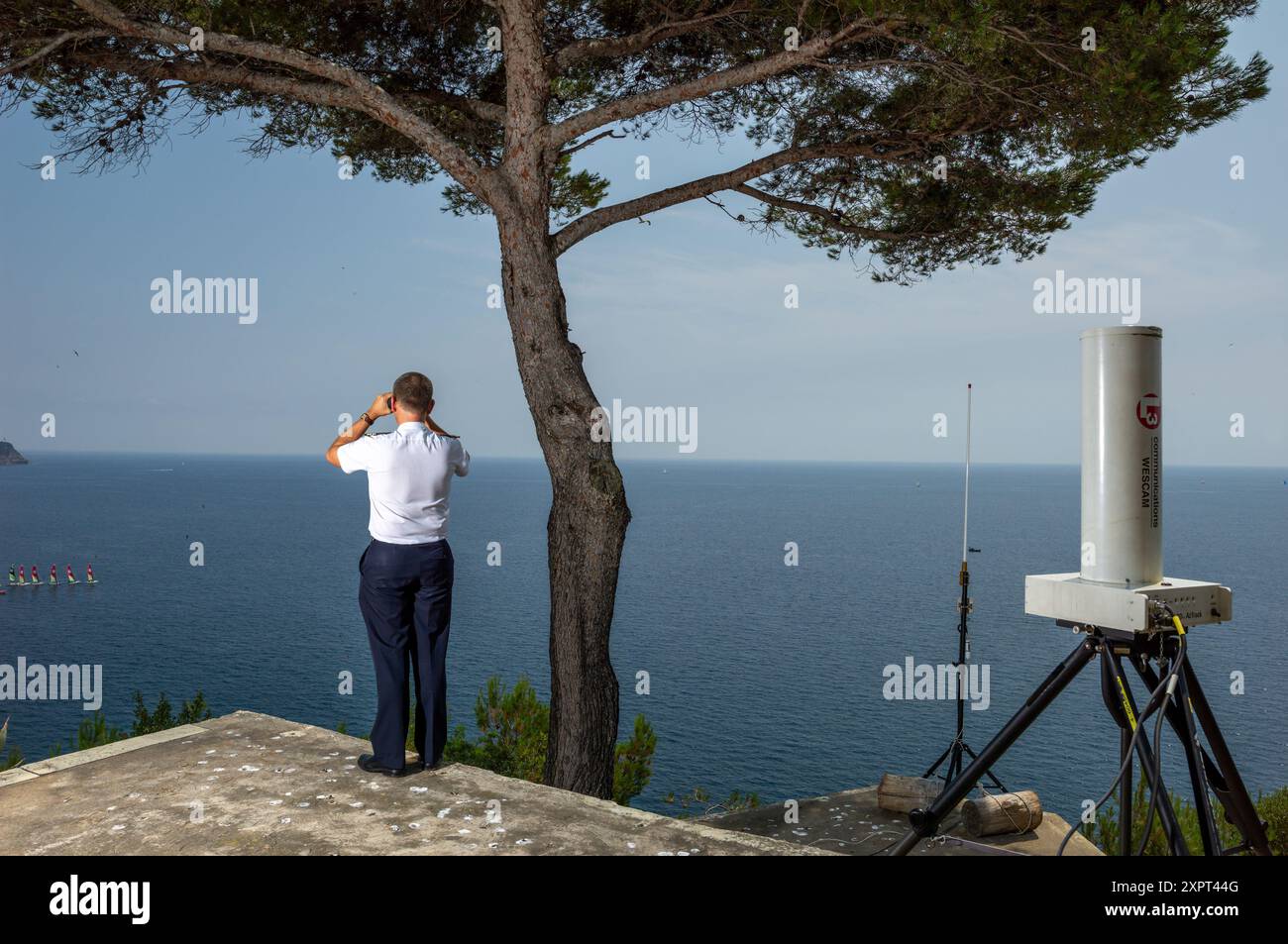 Border guard observing the coastline with surveillance equipment as ...