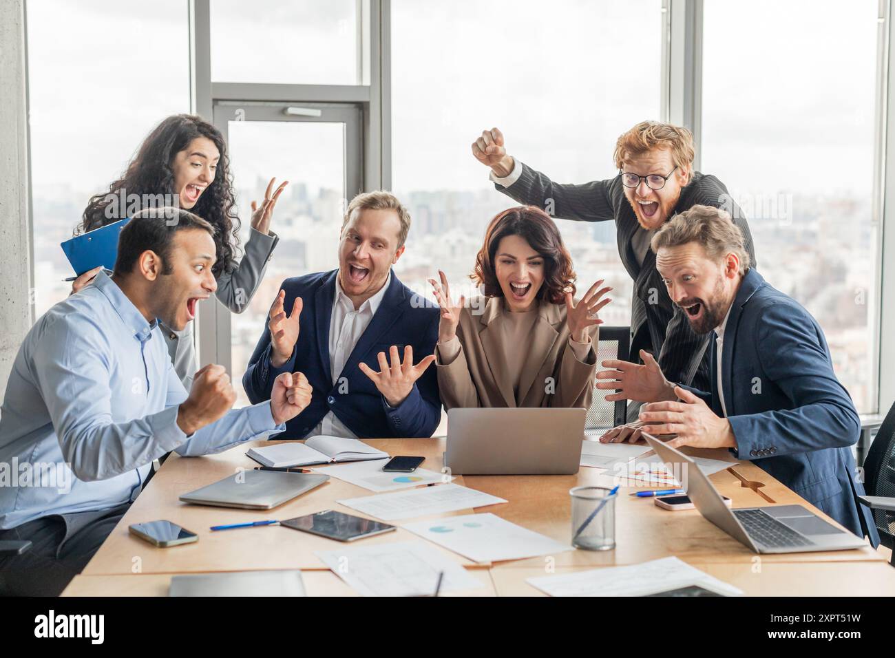 Excited Business Team Celebrating Success Around a Conference Table ...