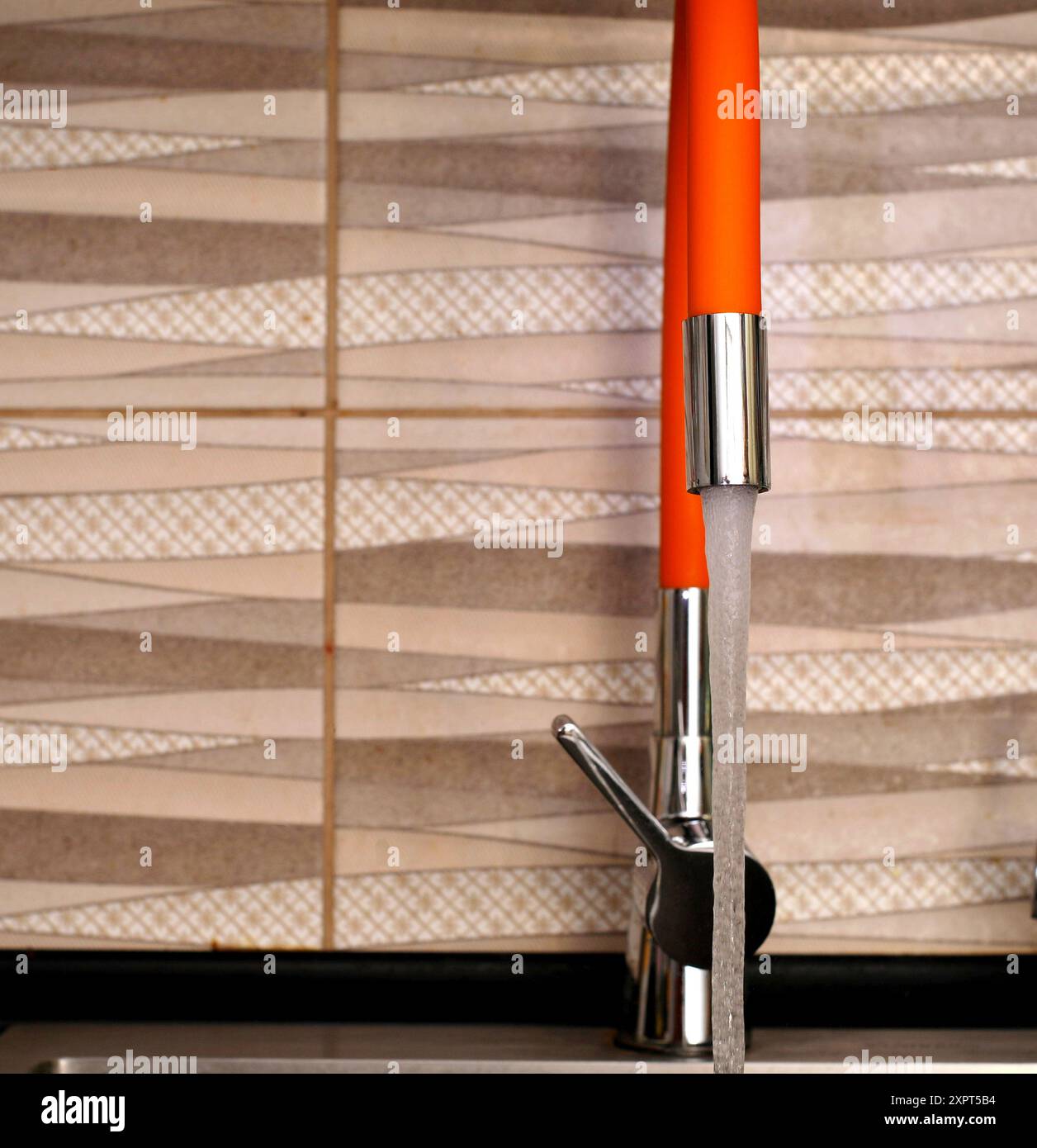 Pictured is a domestic tap mixer tap with a jet of water flowing out ...