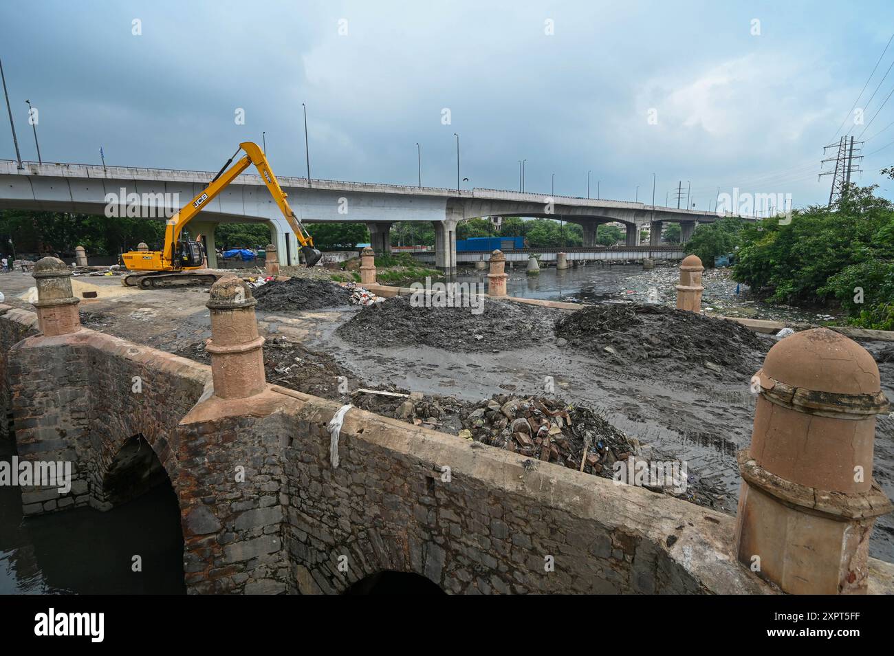 NEW DELHI, INDIA - AUGUST 7: A crane clearing sludge from Barapullah ...