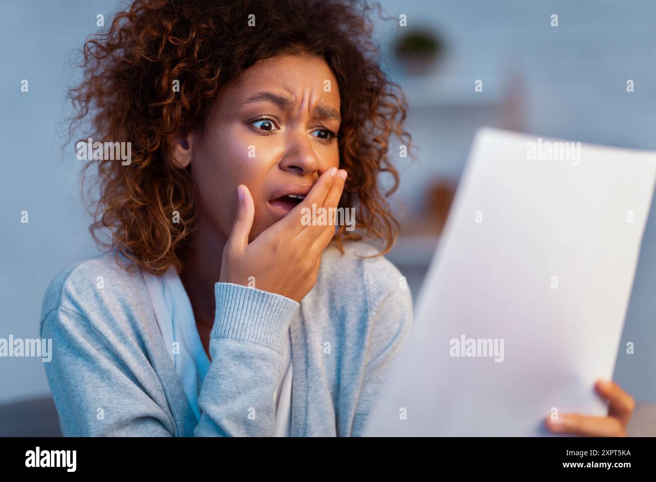 Shocked woman reading unexpected letter from husband Stock Photo - Alamy