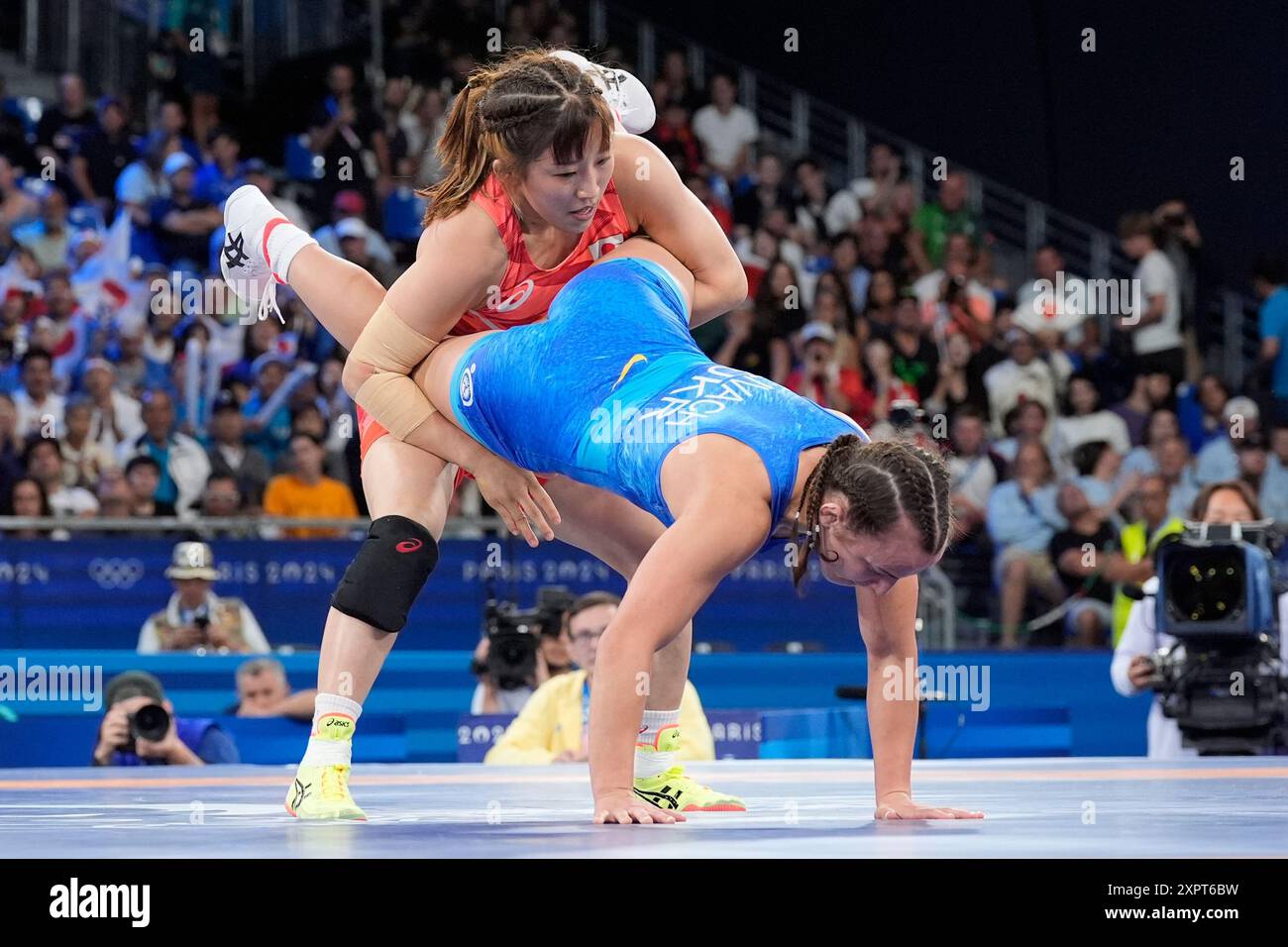 Japan's Yui Susaki and Ukraine's Oksana Livach, bottom, compete in ...
