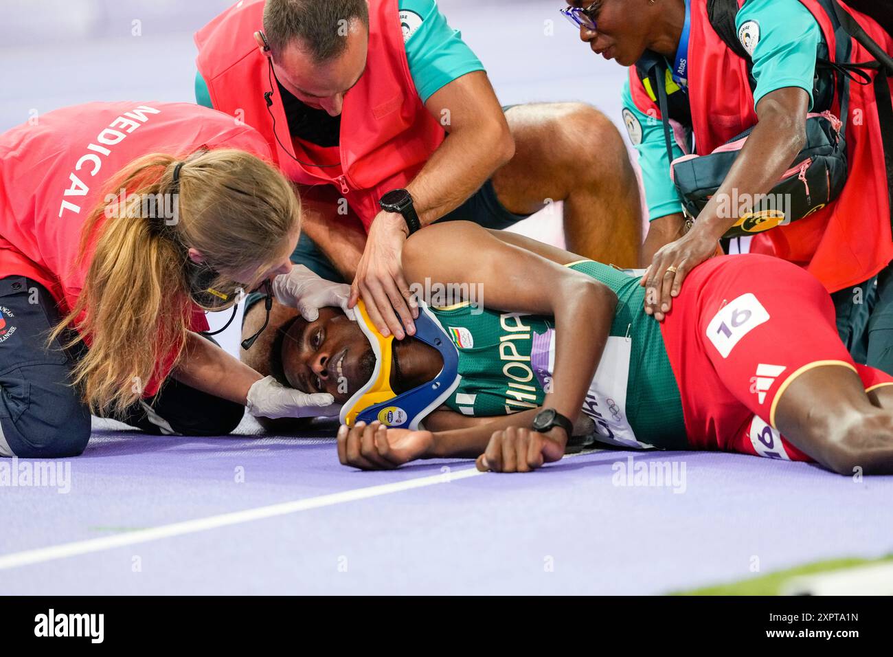 Lamecha Girma, of Ethiopia, is treated on the track after being injured ...