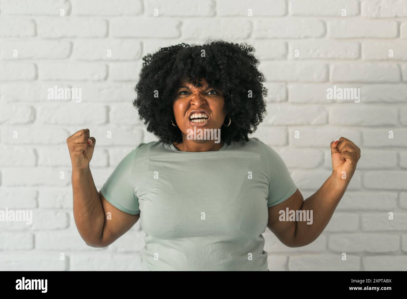 Angry millennial african american woman screaming on brick background ...