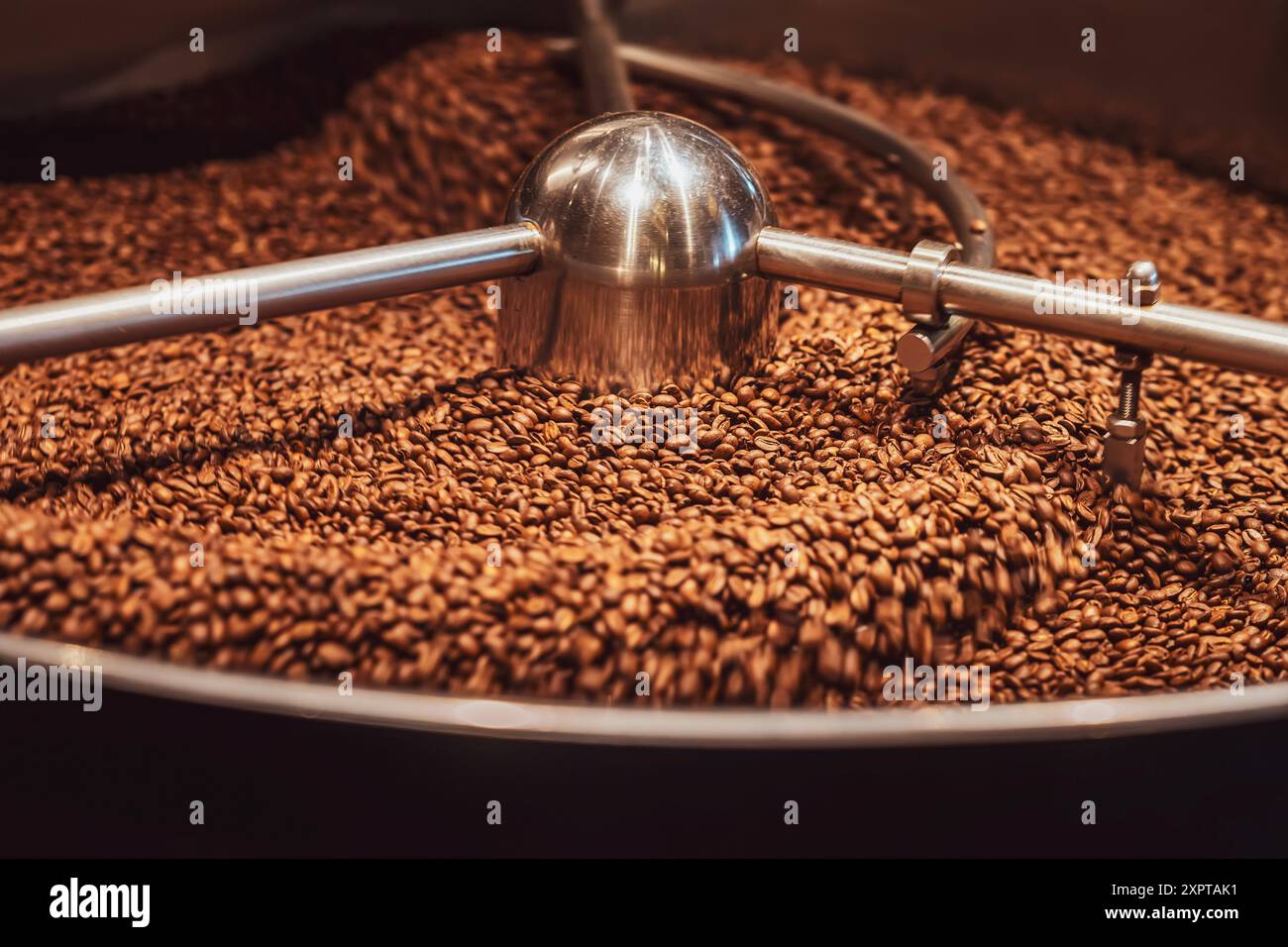 Close-up of freshly roasted coffee beans cooling in a large industrial ...