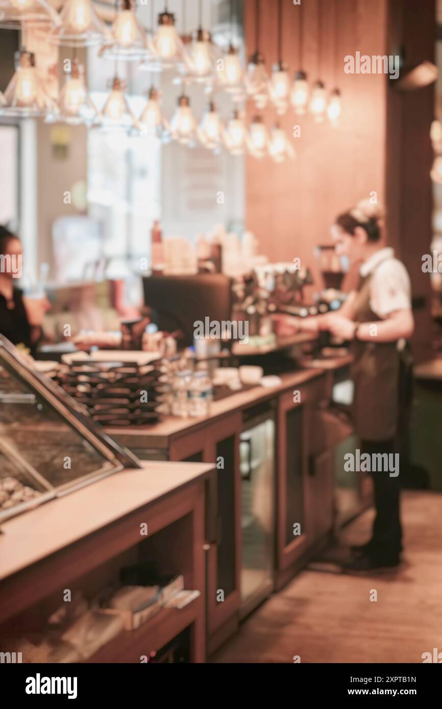 Coffee shop counter with baristas serving customers, stacks of packaged ...
