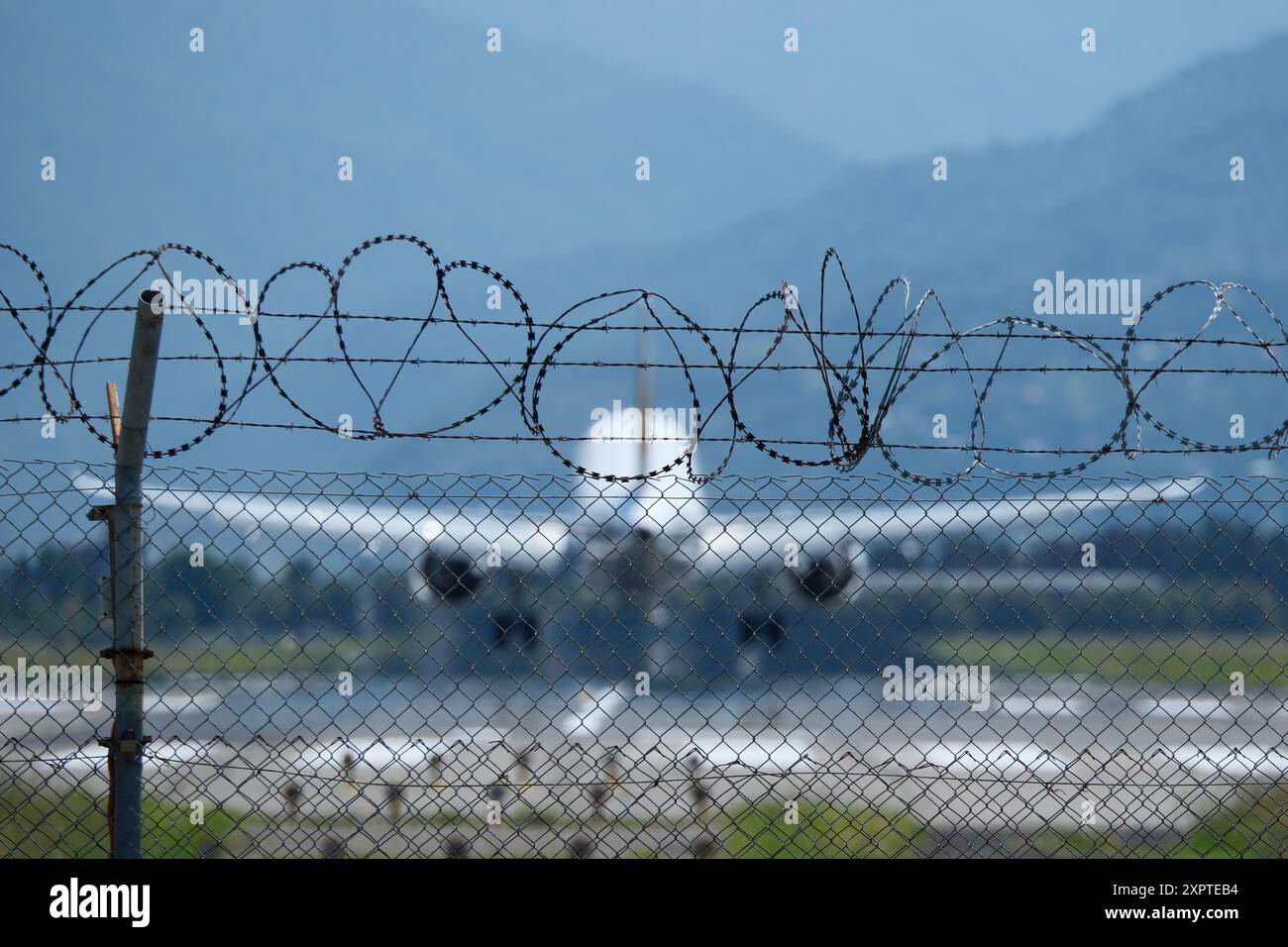 Barbed wire on the background of the airport runway with a plane Stock ...