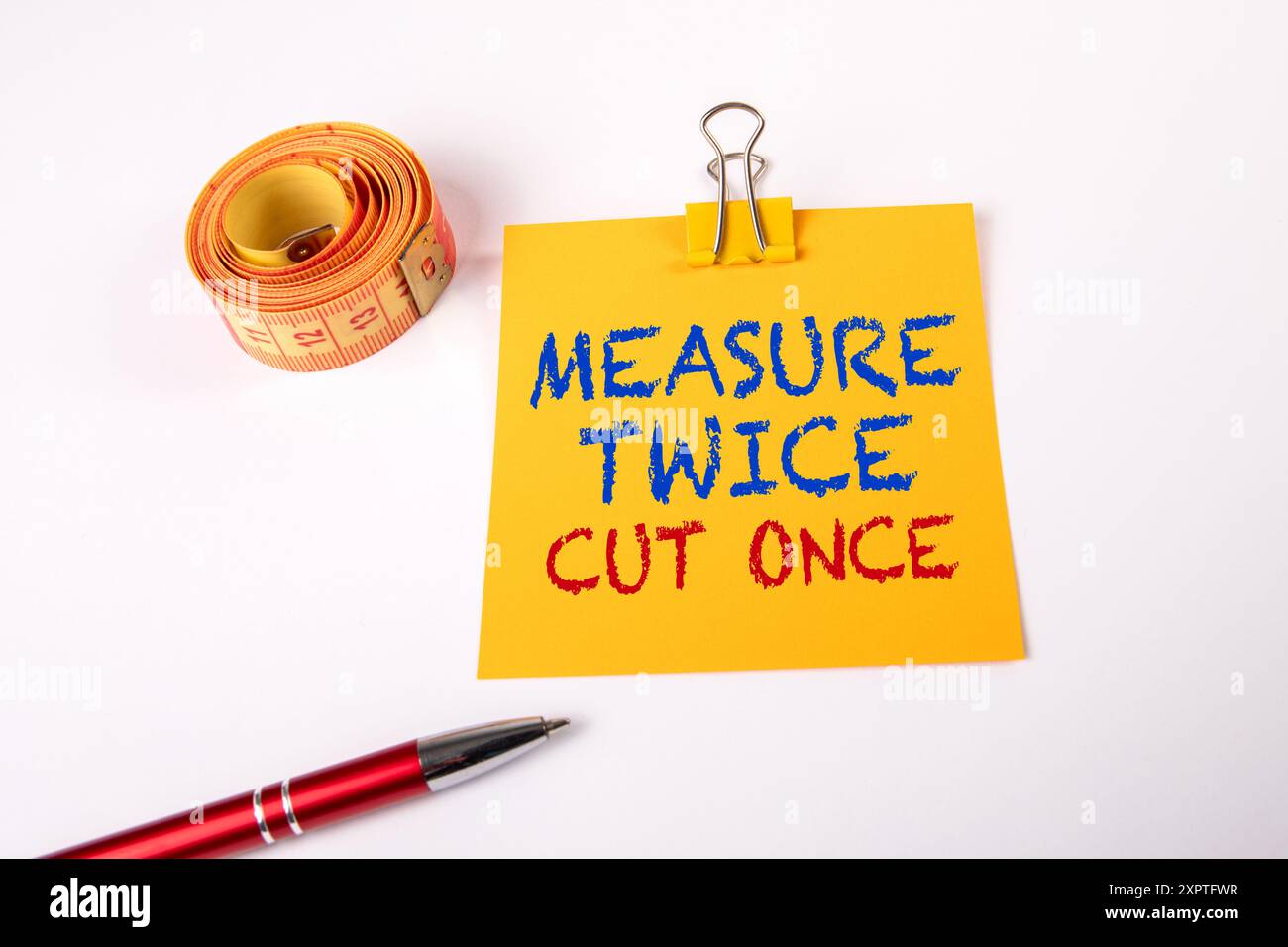 Measure twice, cut once. Yellow notepad and measuring tape on white ...